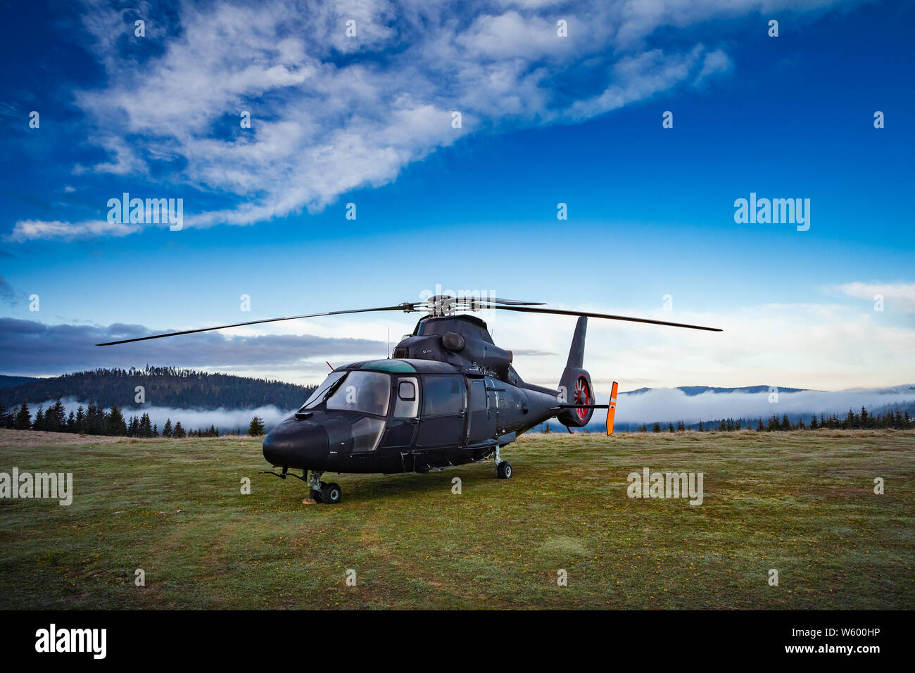 Back private helicopter in mountain landscape Stock Photo - Alamy