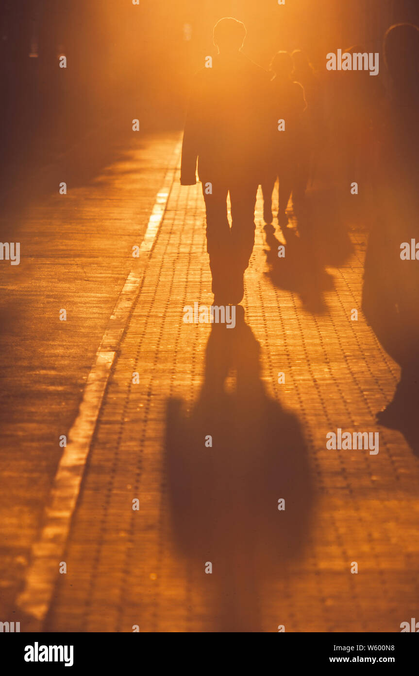 People silhouettes walking through the city at sunset Stock Photo - Alamy
