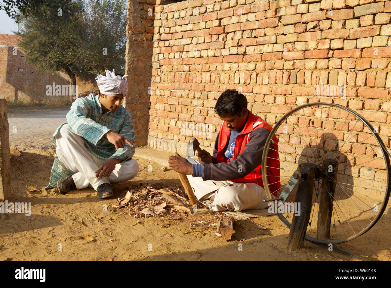 Blacksmith making a hammer and a farmer guiding him Stock Photo - Alamy