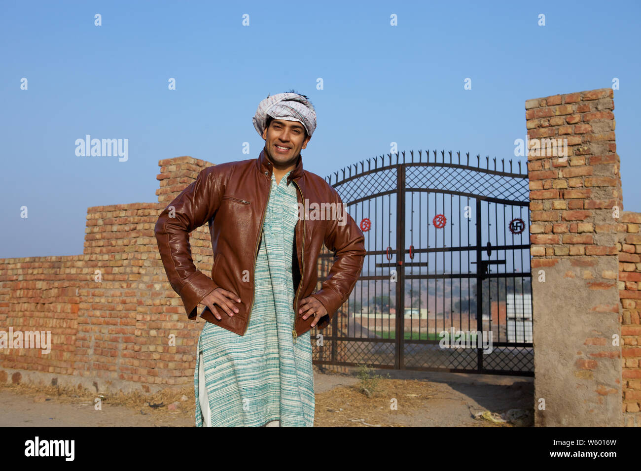 Rural man smiling with his arms akimbo Stock Photo - Alamy