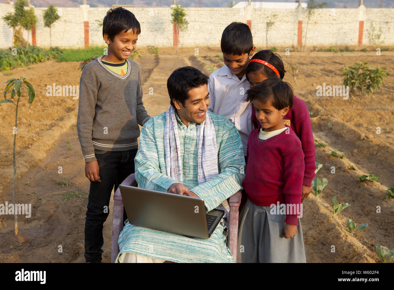Man explaining to students on a laptop Stock Photo - Alamy