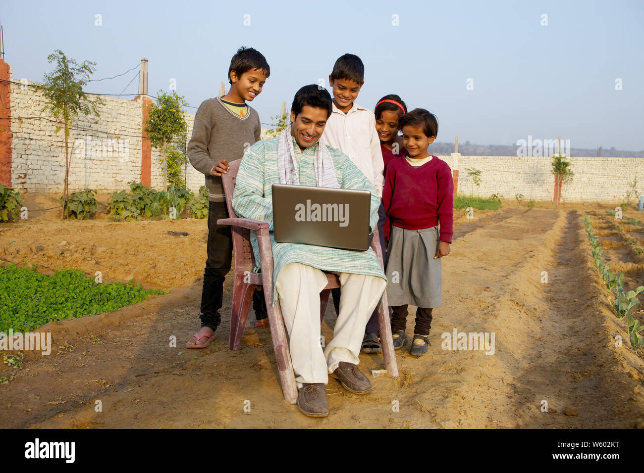 Man explaining to students on laptop Stock Photo - Alamy