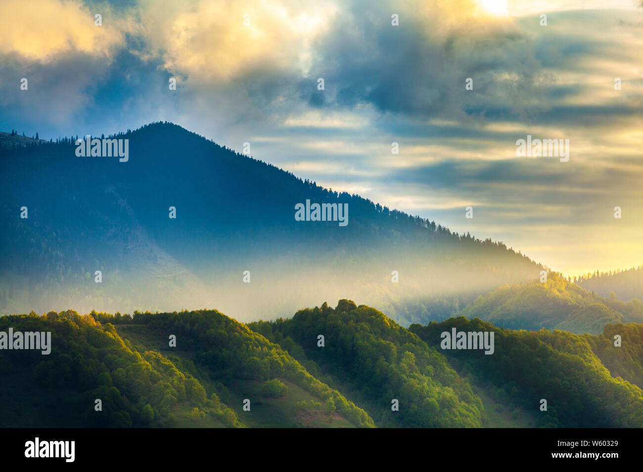 Sun rays beams over rural mountain resort epic landscape Stock Photo ...