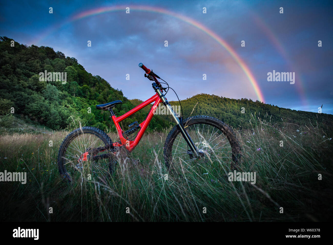 Mountain bike in beautiful nature scene with hills and rainbow Stock ...