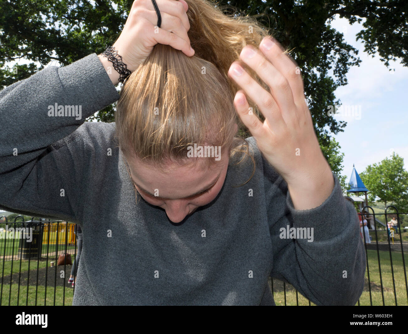 Blonde Teenage girl messing around with her messy hair Stock Photo - Alamy