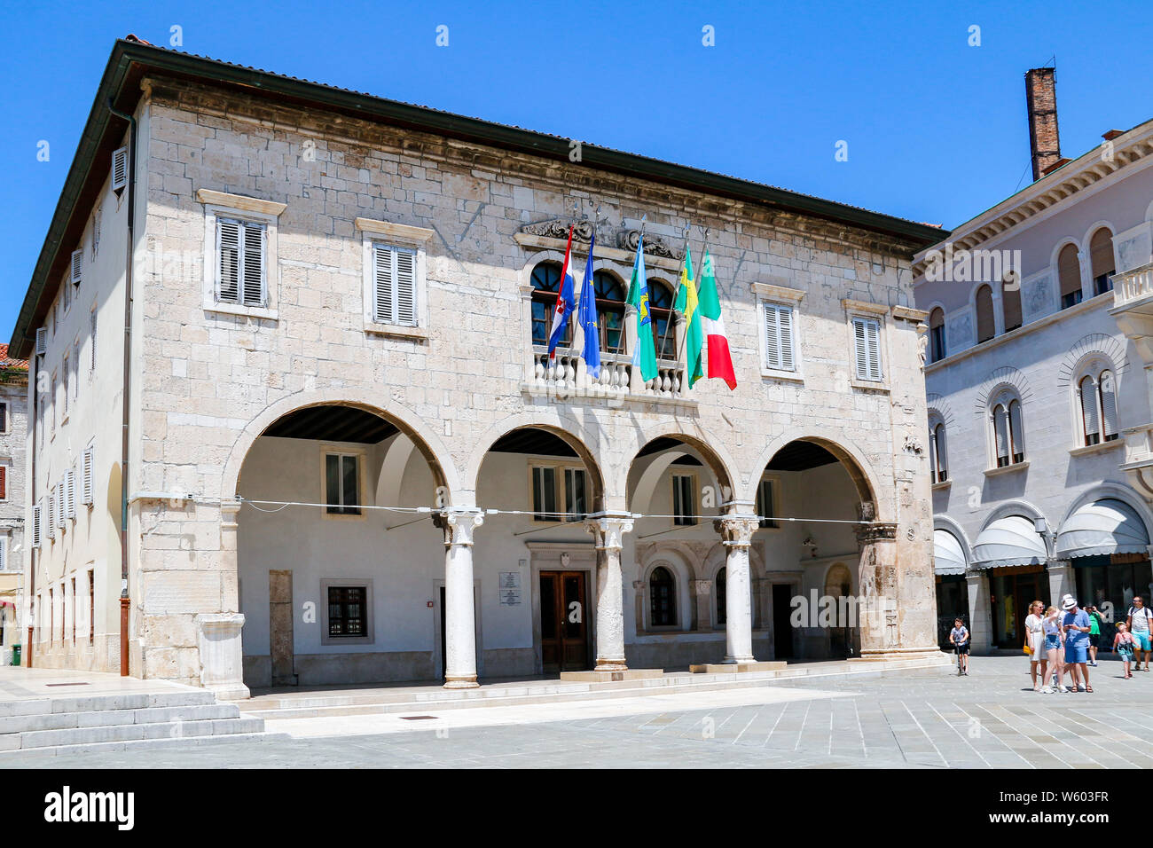 Tourists outside the ancient Roman Communal Palace in Forum Square ...