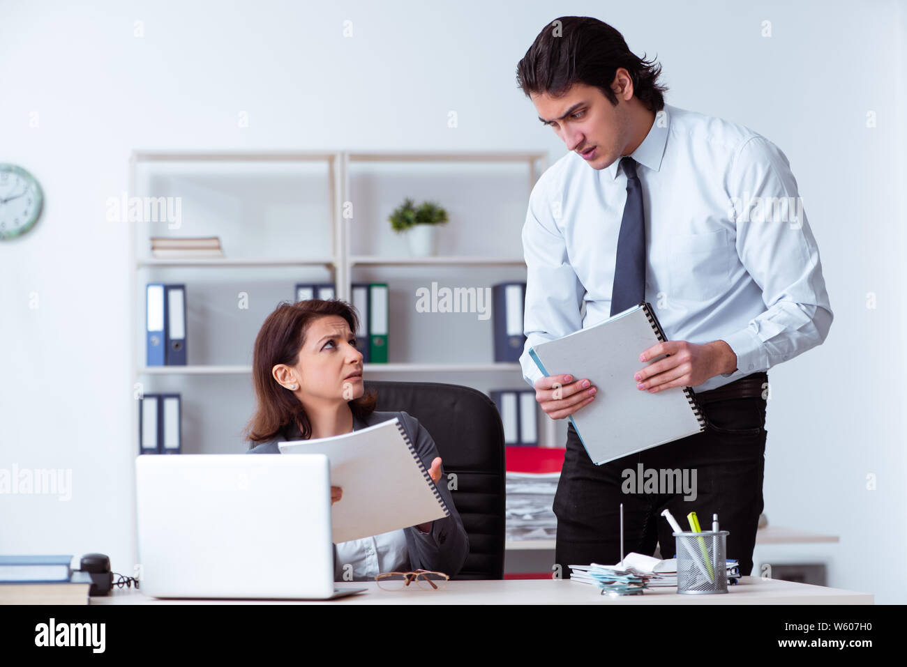 The old female boss and young male employee in the office Stock Photo ...