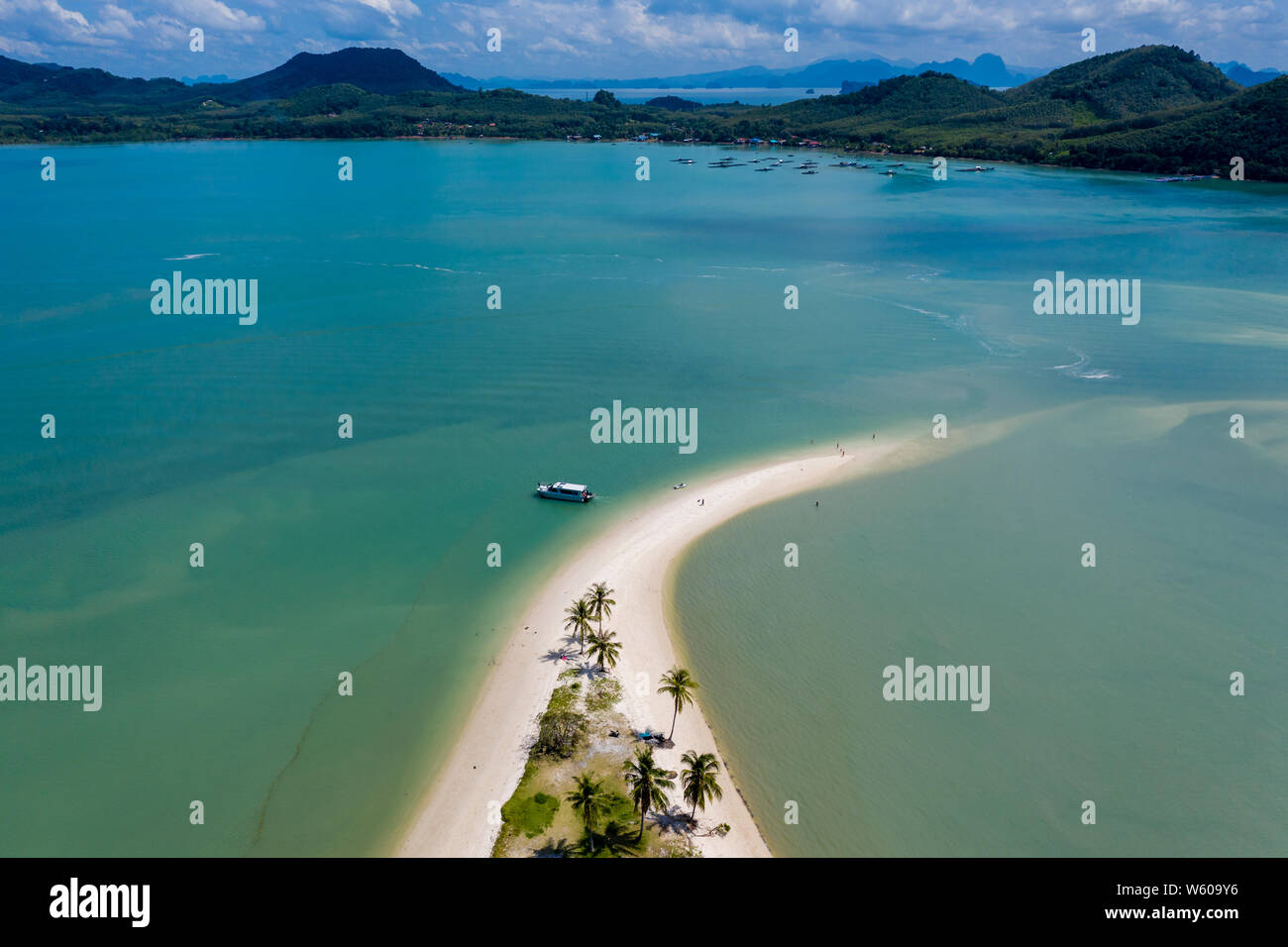 Aerial view of a sand spit leading into the ocean from a green ...