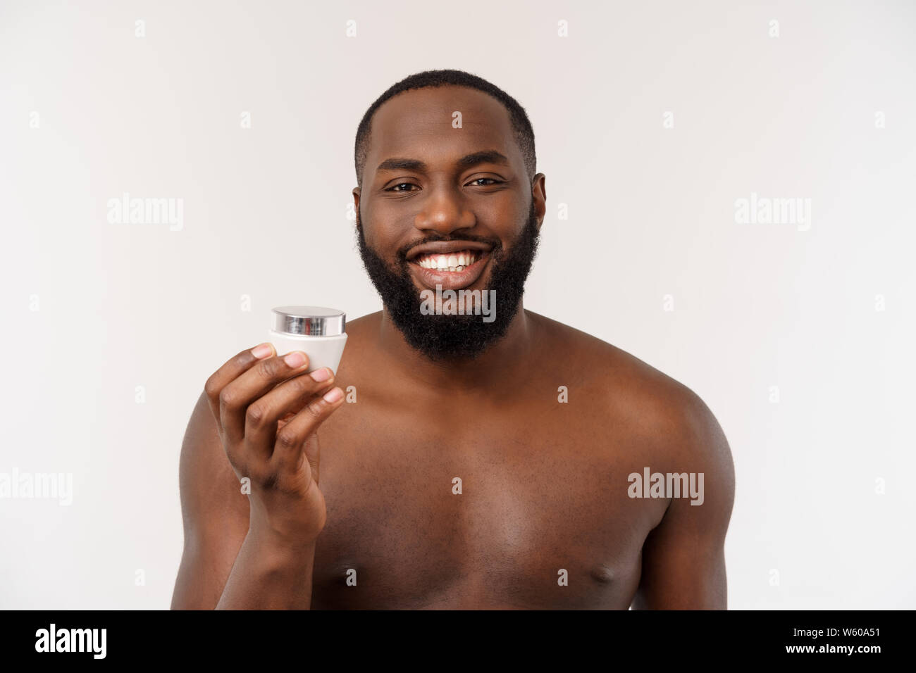Shirtless Young Brutal African American Man Applying Facial Cream On