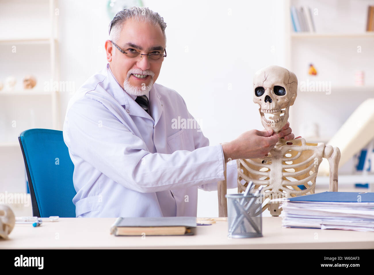 The aged male doctor with skeleton Stock Photo - Alamy