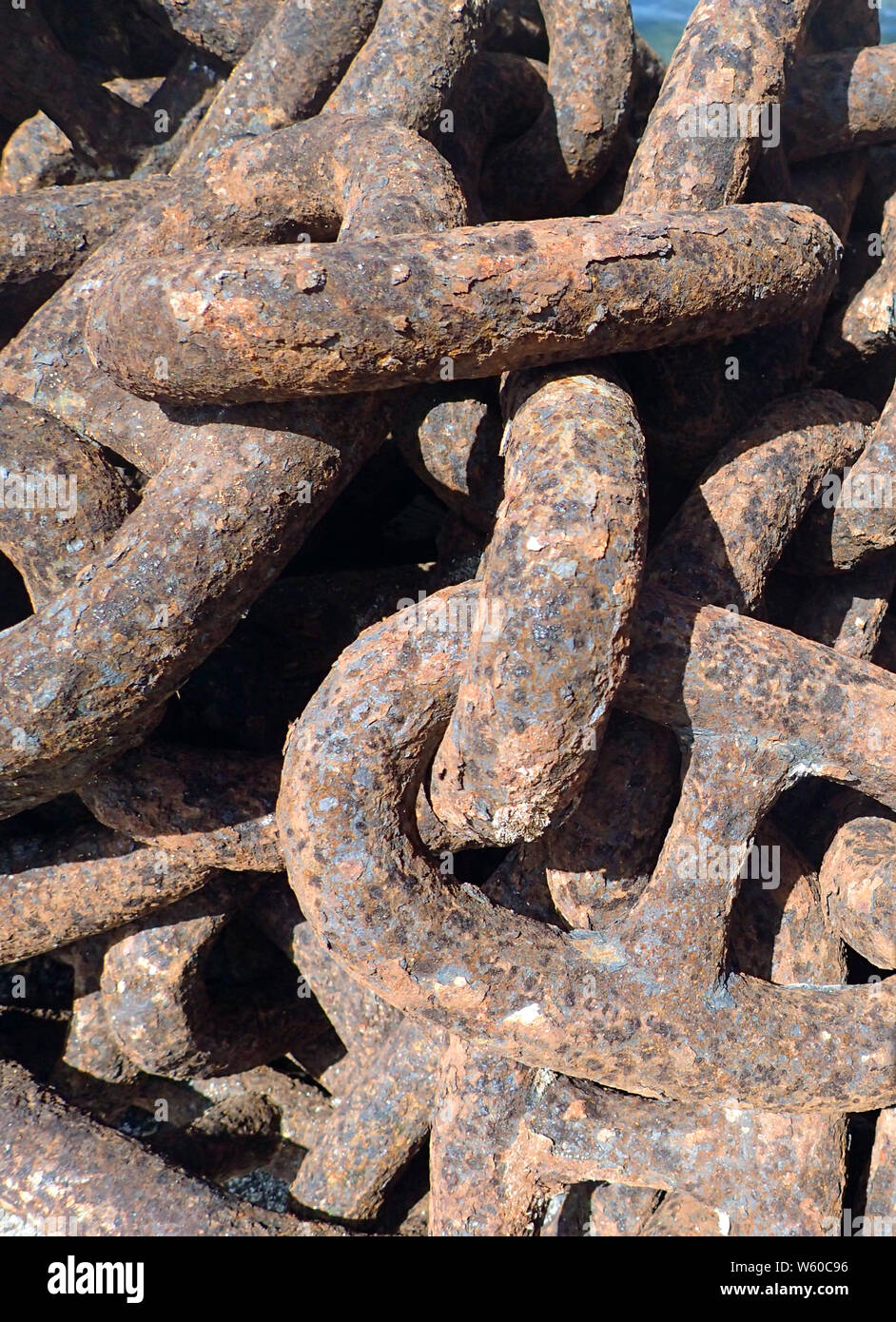 Close up of a pile of rusted steel chain with large oval links, with ...