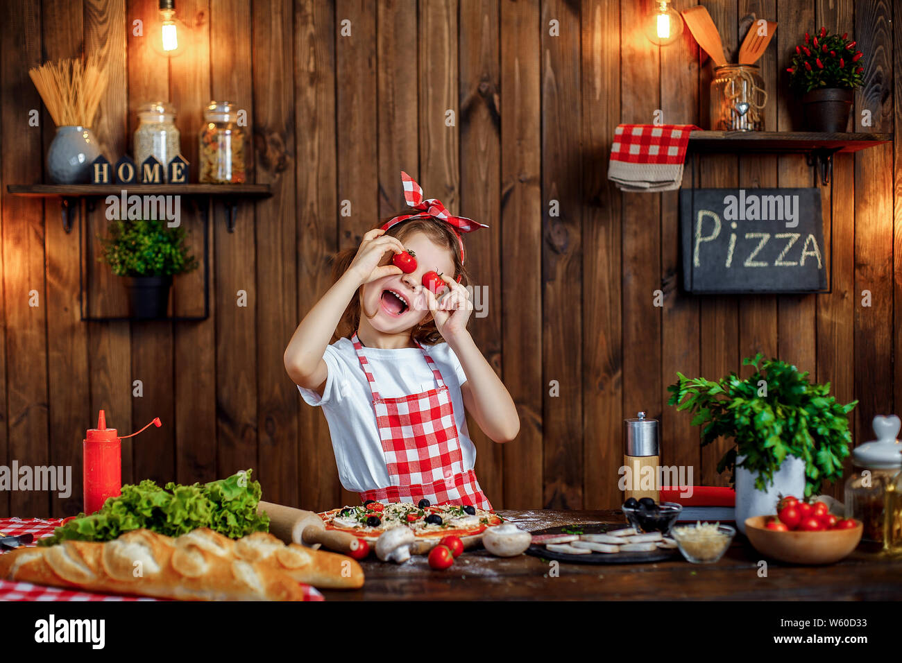 Adorable little female chef wearing checkered apron and headband ...