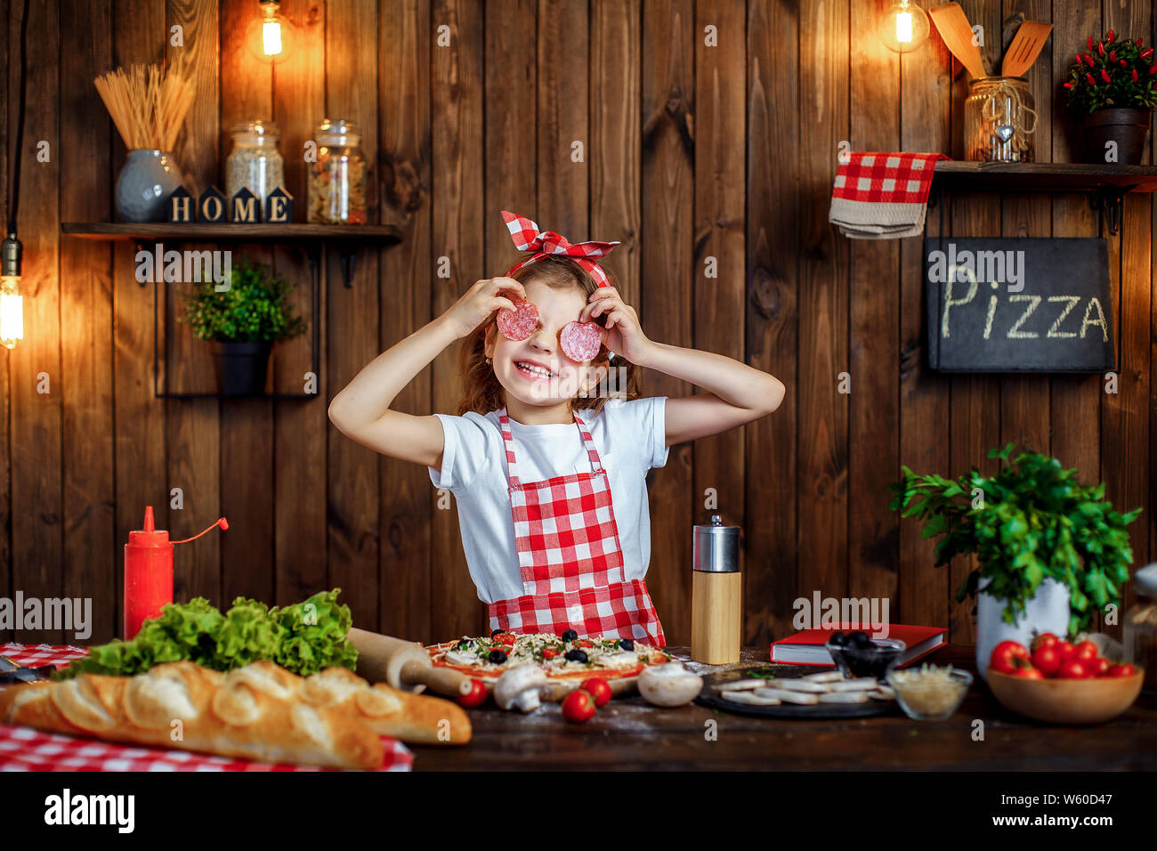 Adorable little female chef wearing checkered apron and headband ...
