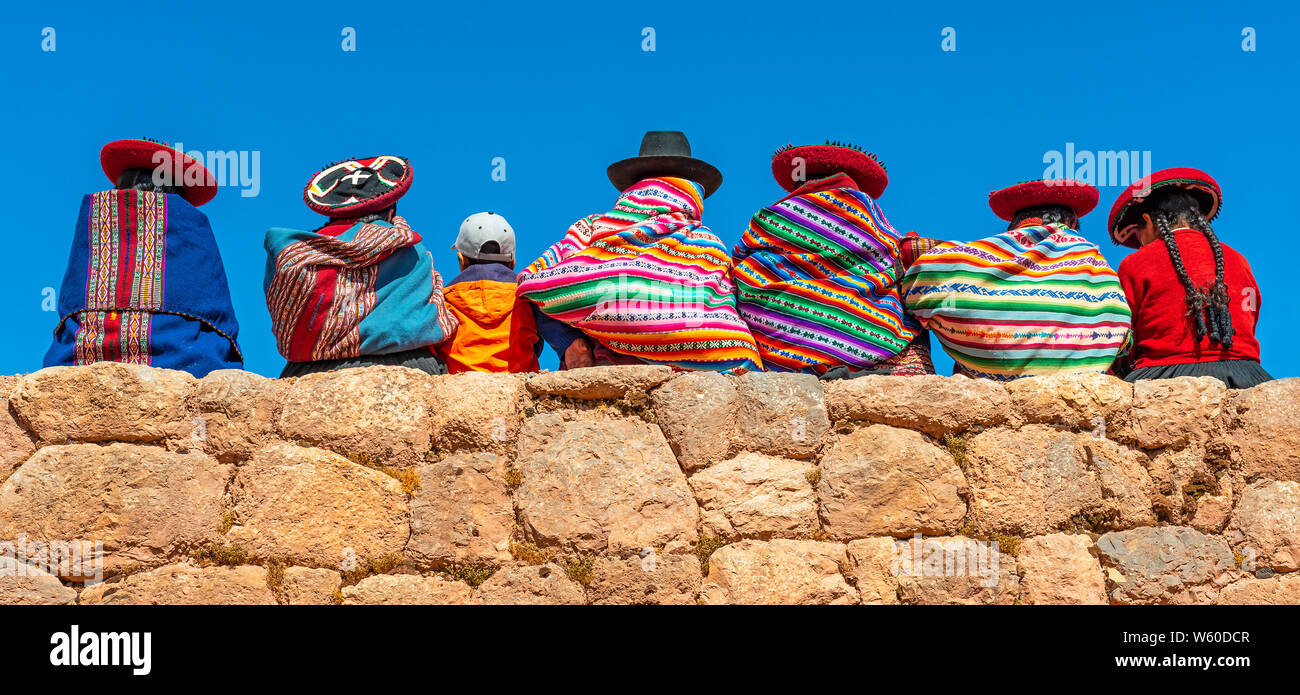 A colourful group of indigenous Quechua women sitting on an ancient ...