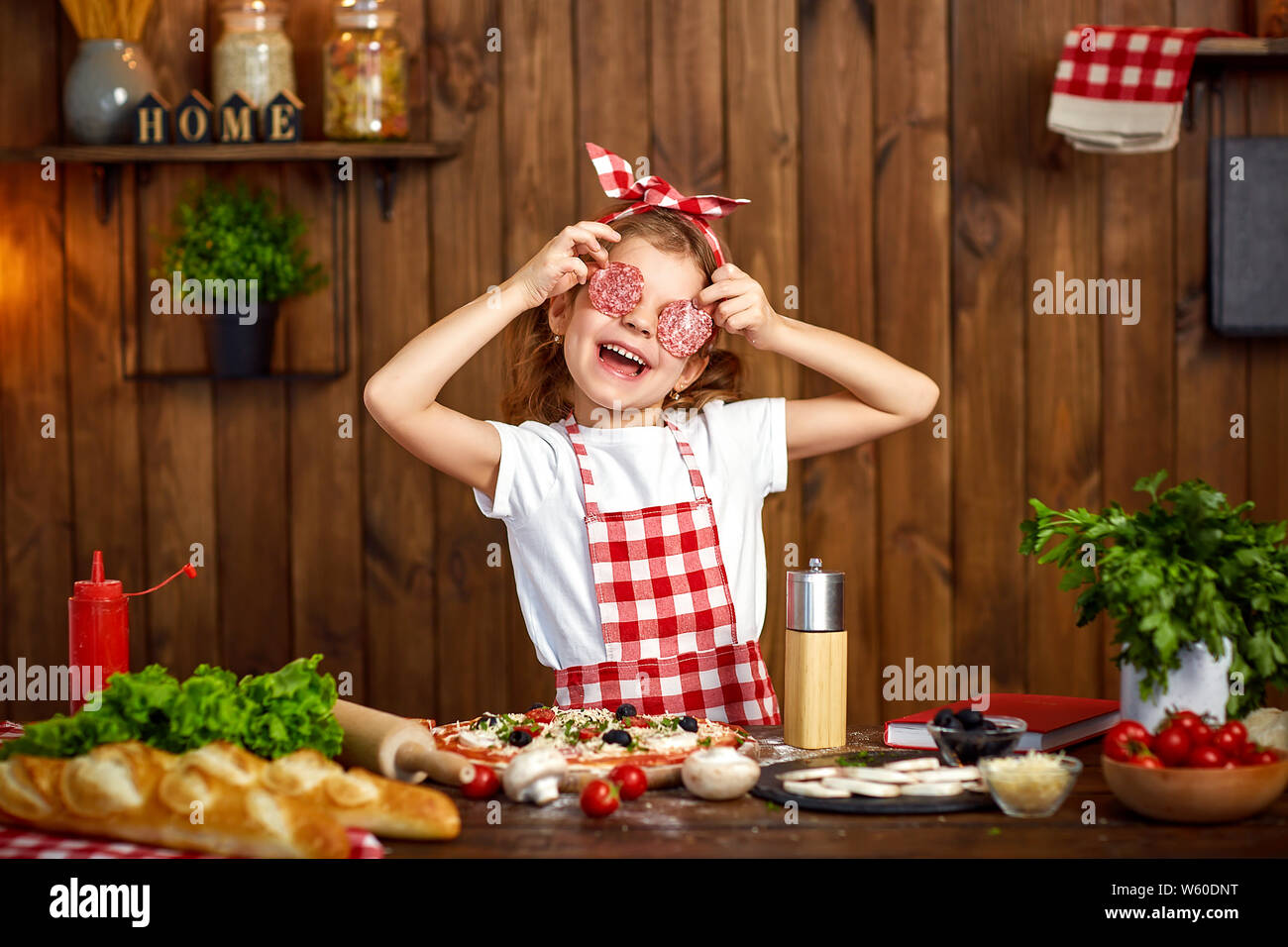 Adorable little female chef wearing checkered apron and headband ...