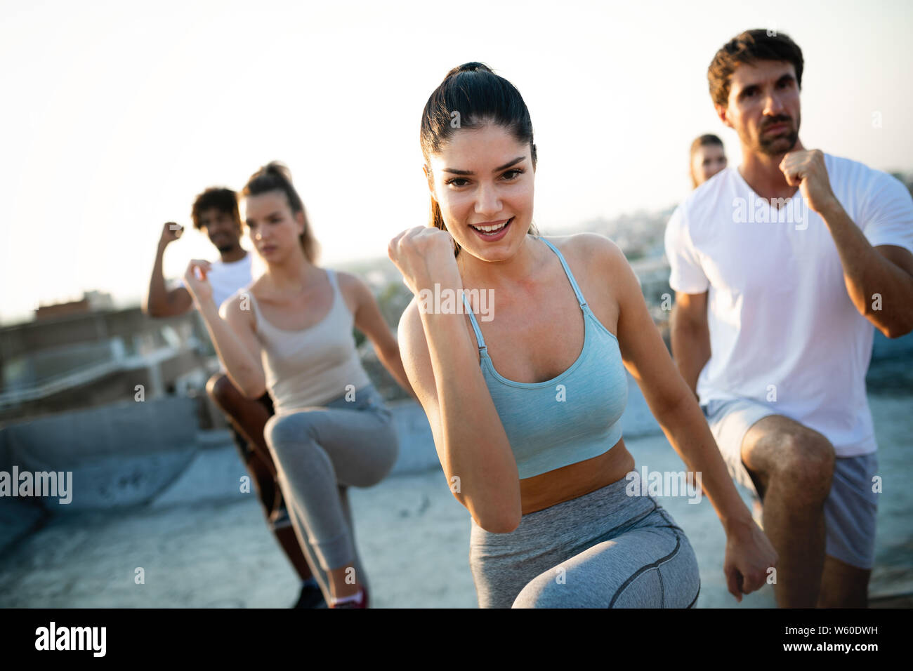 Group of fit healthy friends, people exercising together outdoor on ...