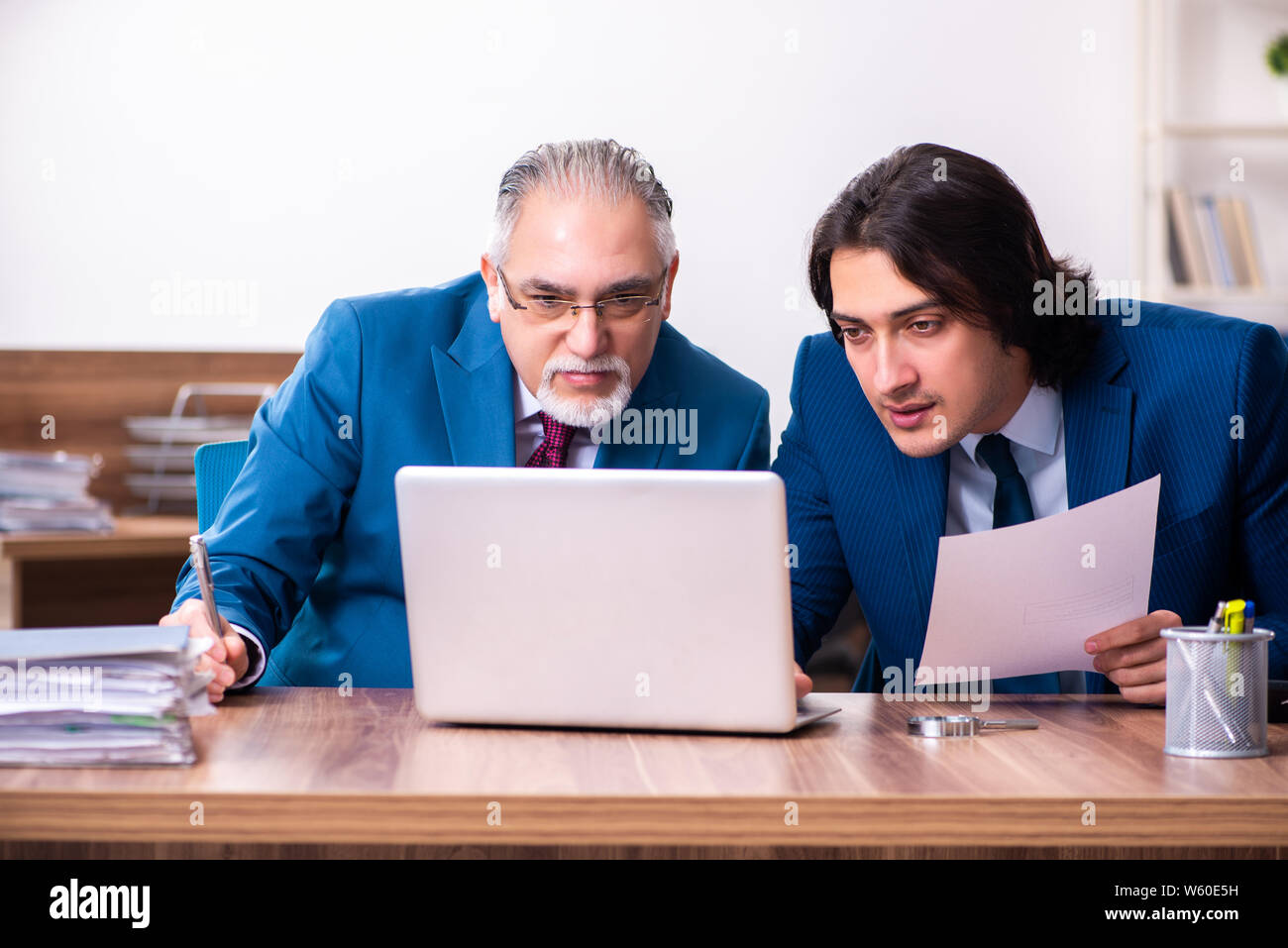The young and old employees working together in the office Stock Photo ...