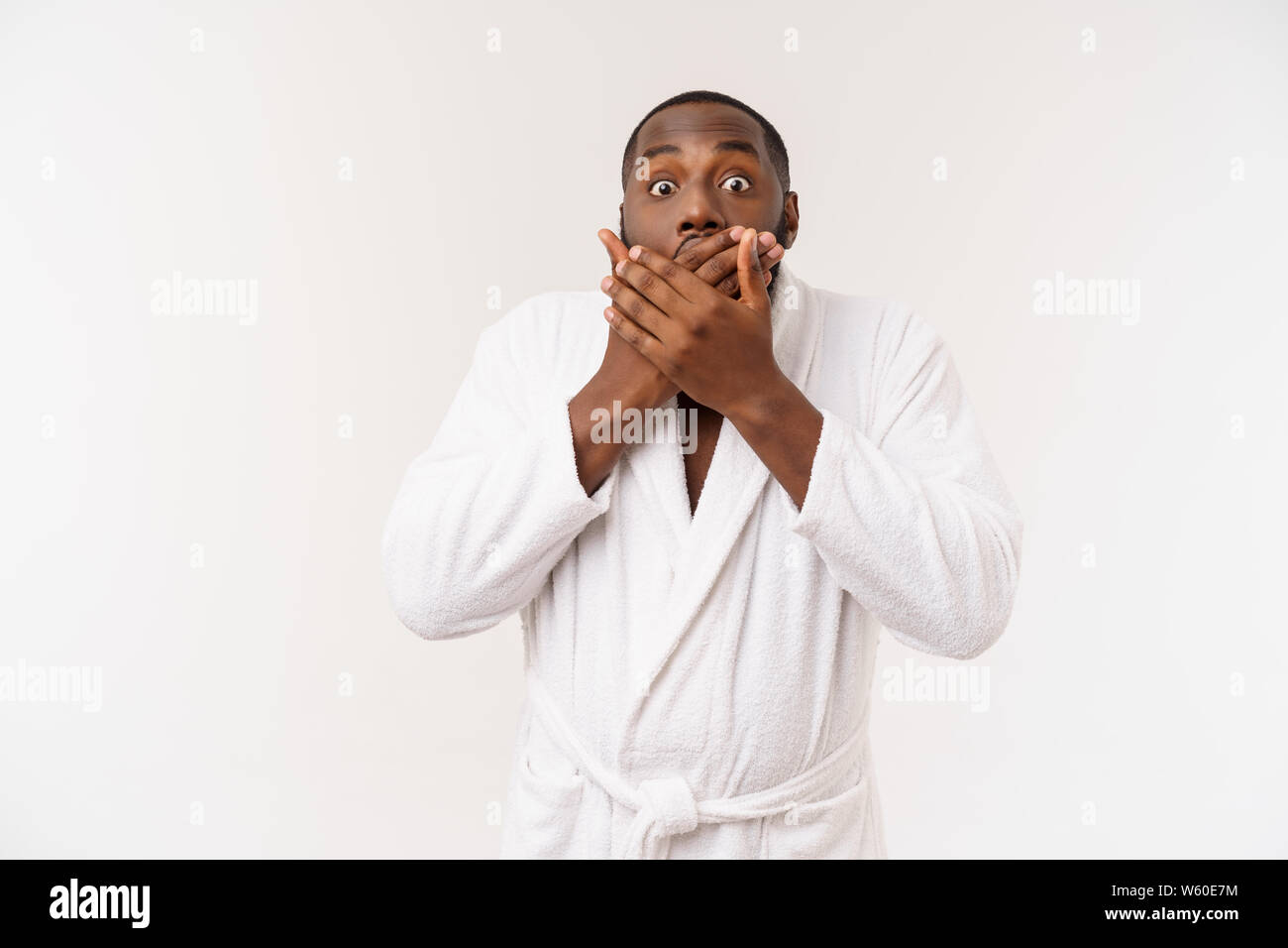 Portrait of excited young African American male screaming in shock and amazement holding hands ...