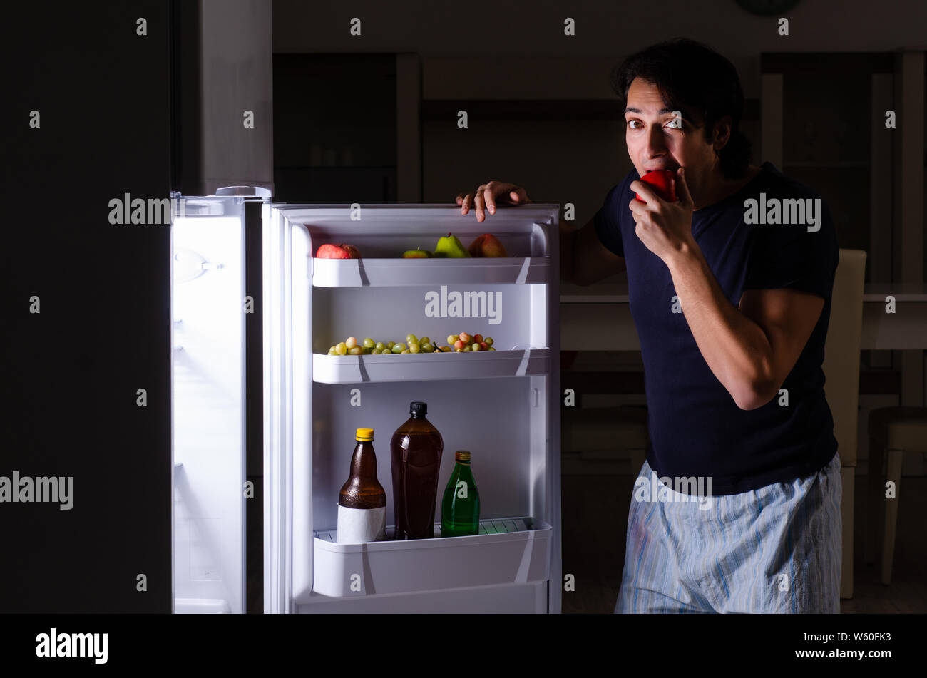 The man breaking diet at night near fridge Stock Photo - Alamy