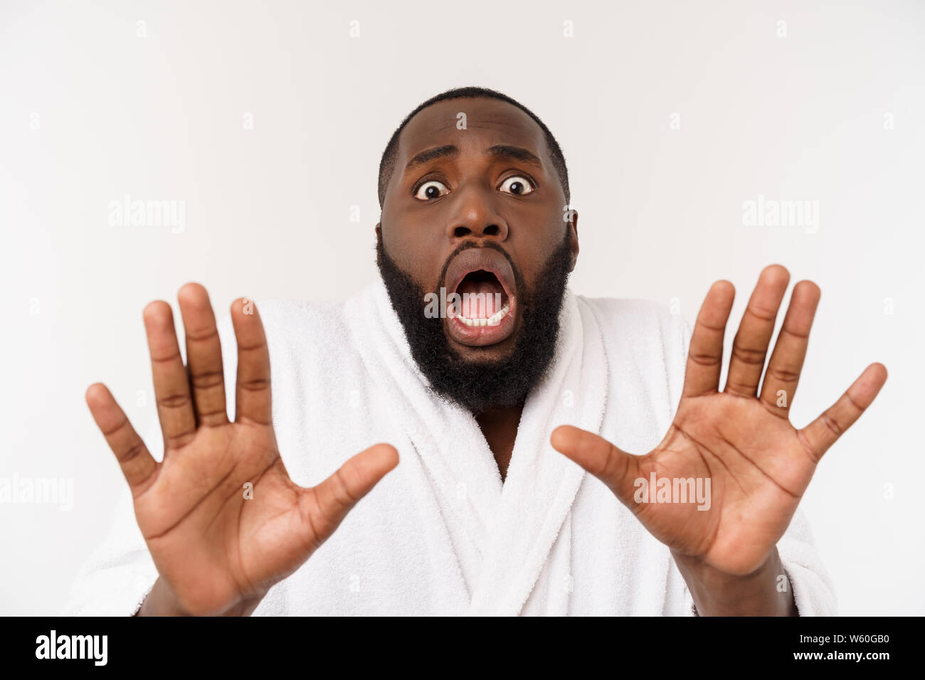 Portrait of excited young African American male screaming in shock and amazement holding hands ...