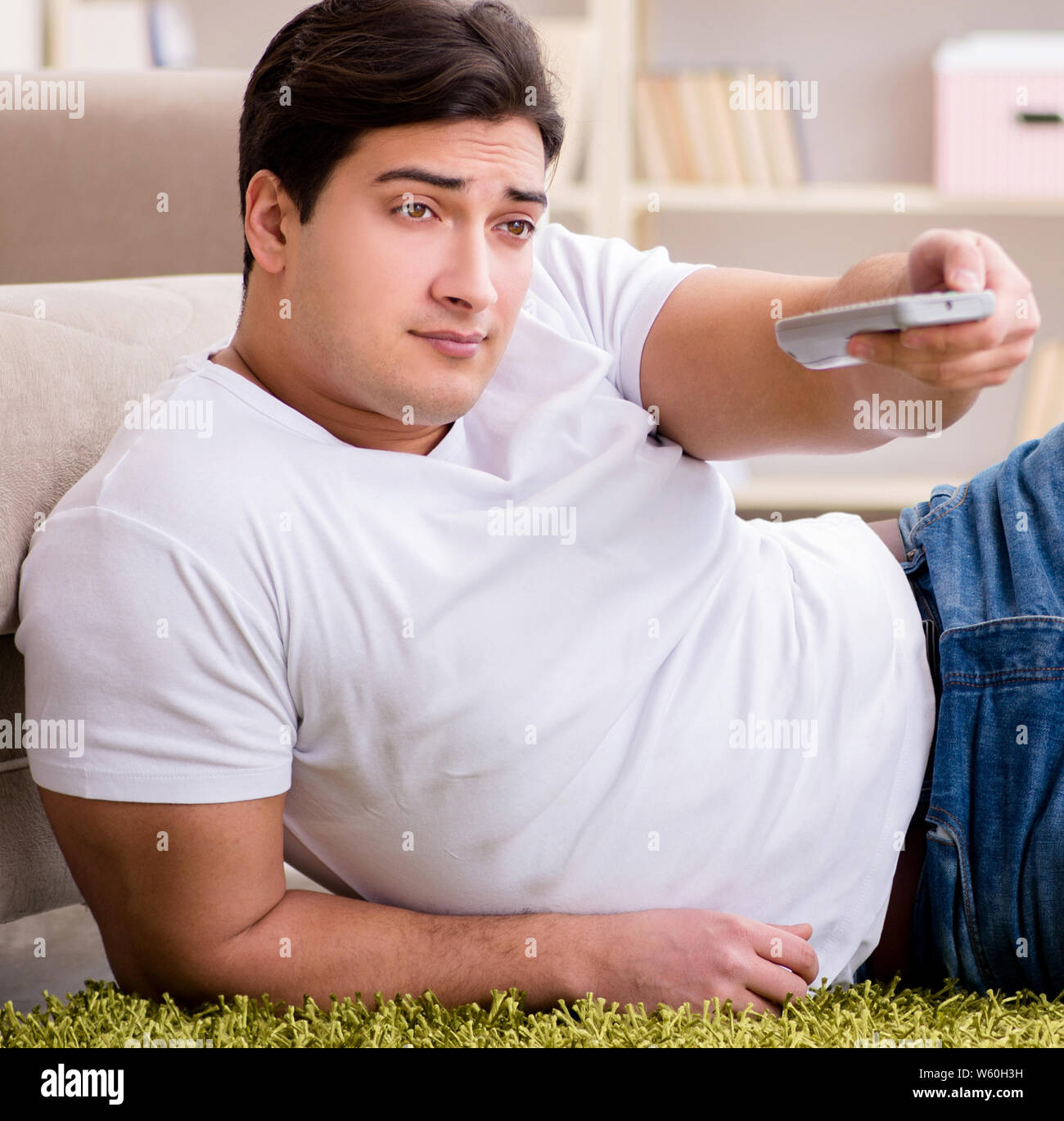 The man watching tv at home on floor Stock Photo - Alamy