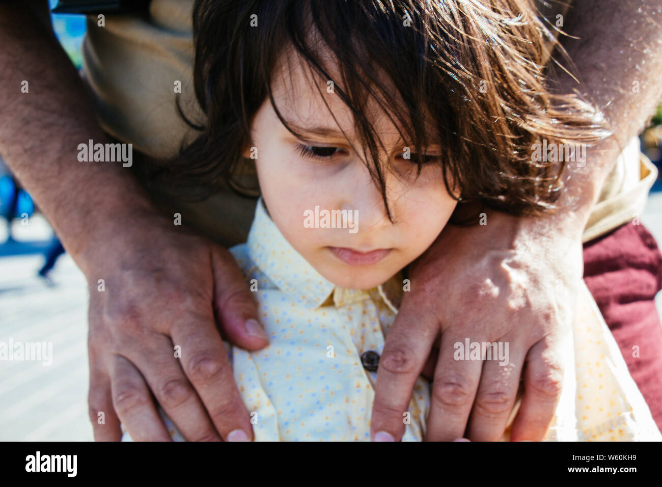 Sad little kid standings with hands on his shoulders Stock Photo - Alamy