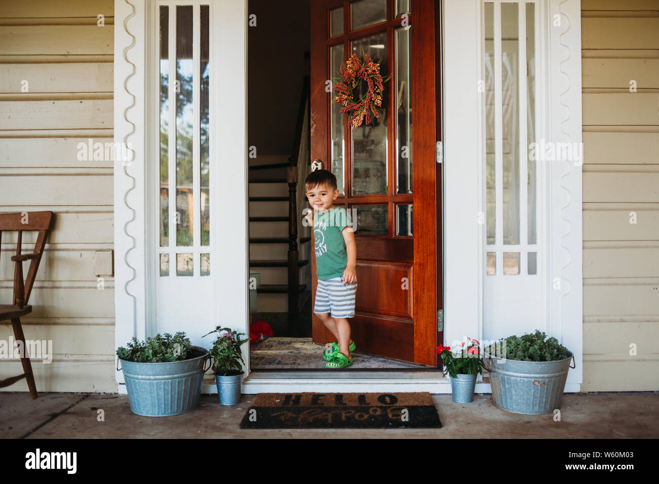 Young boy closing front door in summer Stock Photo - Alamy