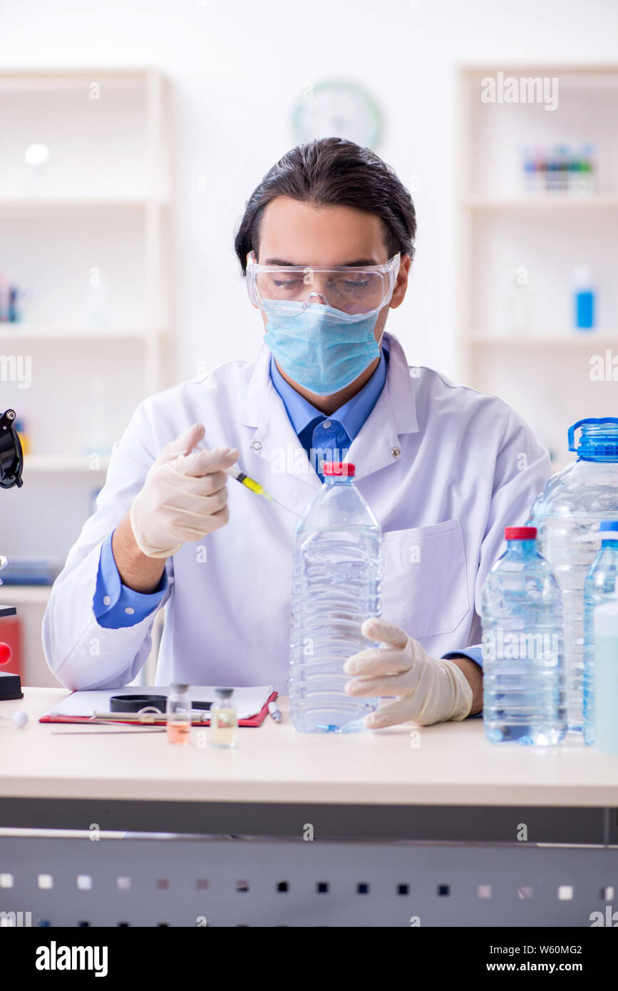 The young male chemist experimenting in lab Stock Photo - Alamy