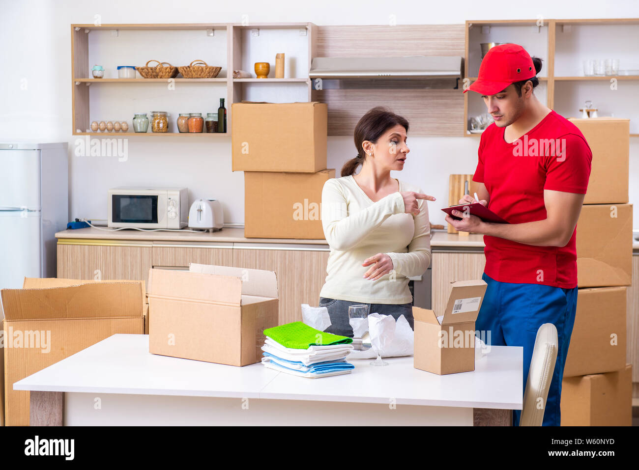 The young male contractor and female customer in moving concept Stock ...