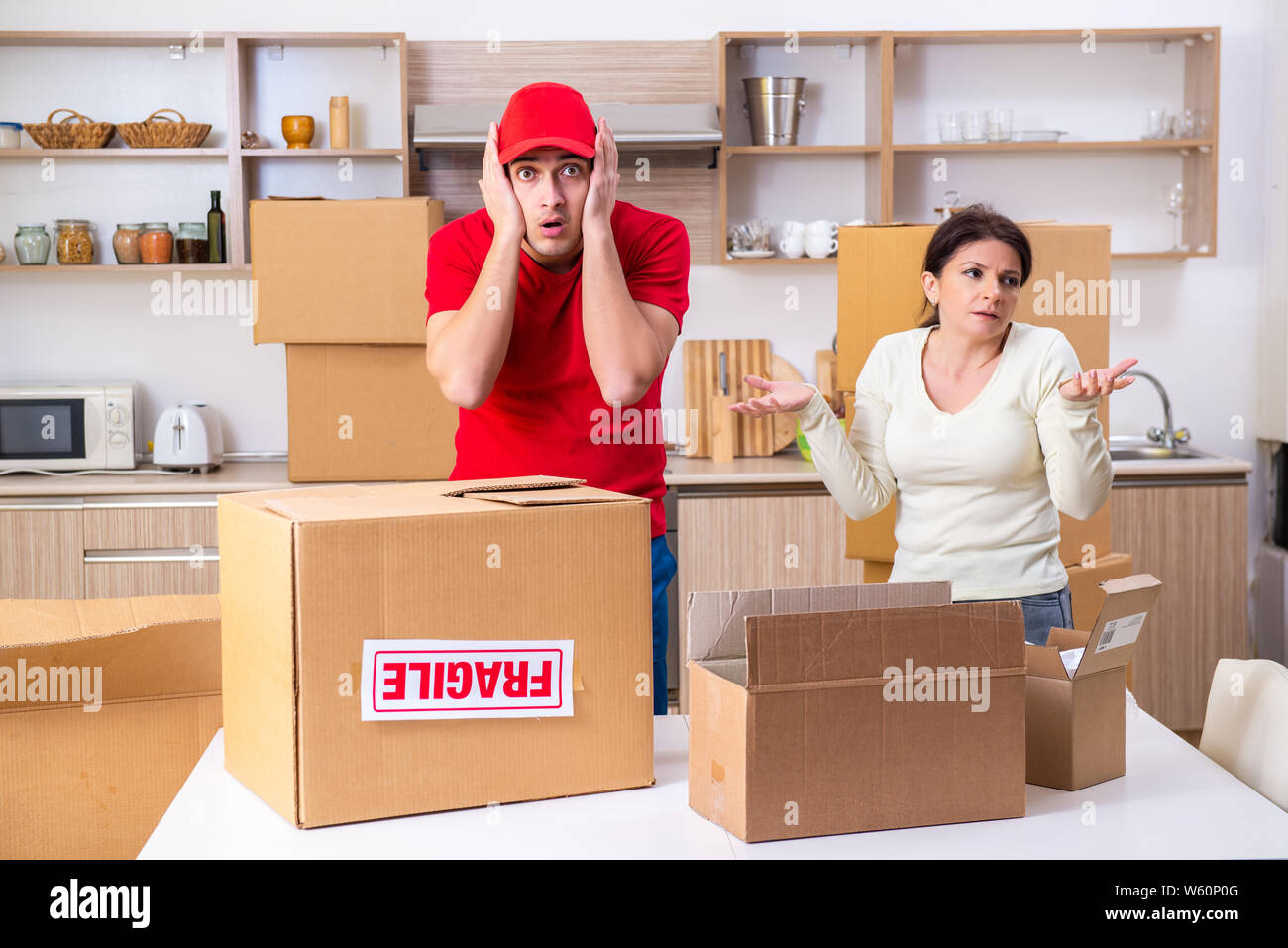 The young male contractor and female customer in moving concept Stock ...