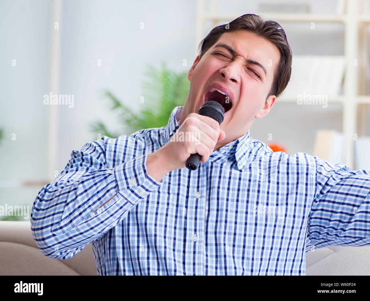 The funny man singing songs in karaoke at home Stock Photo - Alamy