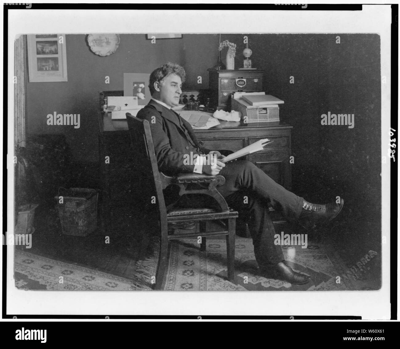David Belasco, full-length portrait, seated at desk, facing right ...