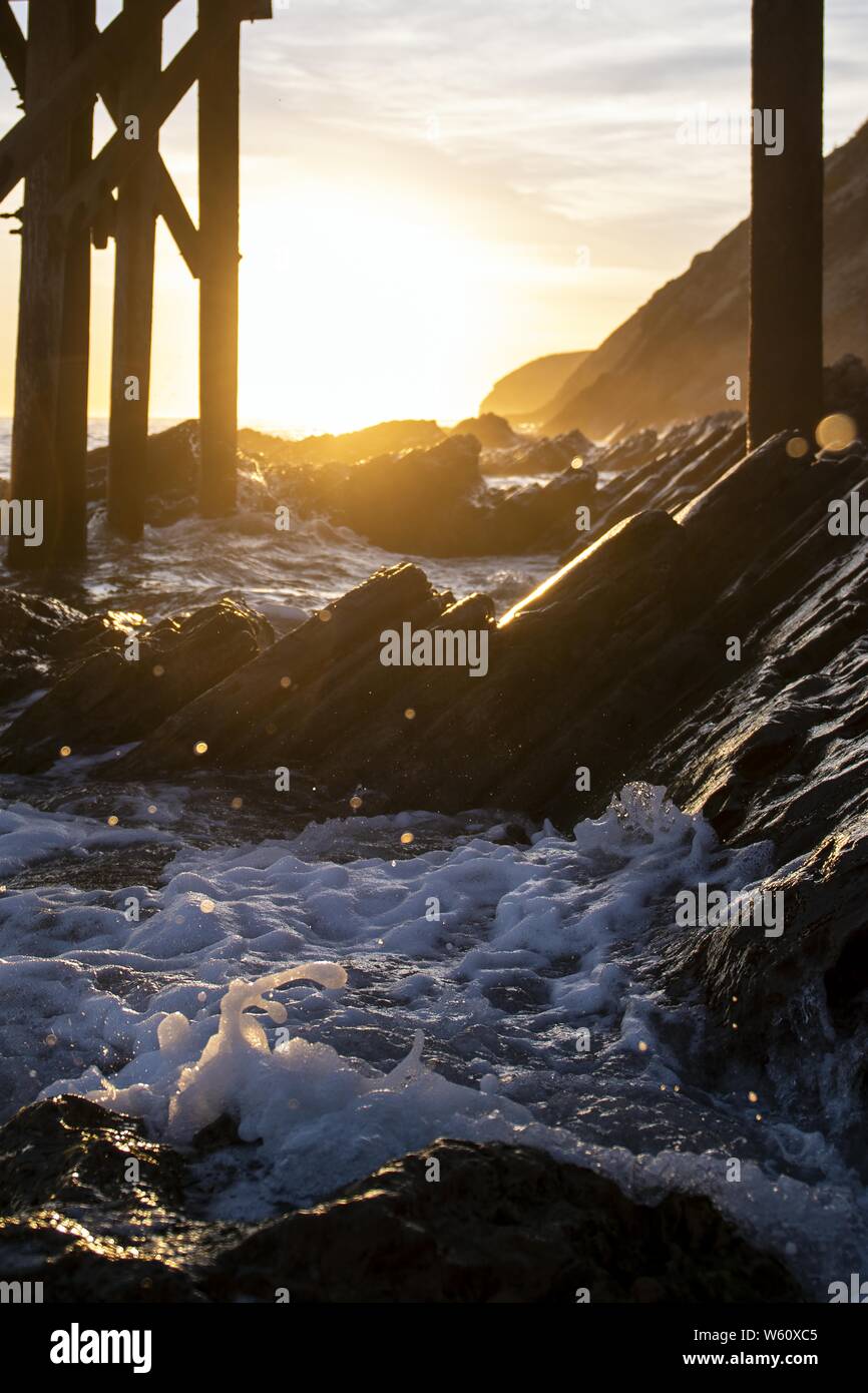 Beautiful ocean waves on spiky rocks at the coast of the sea under the ...