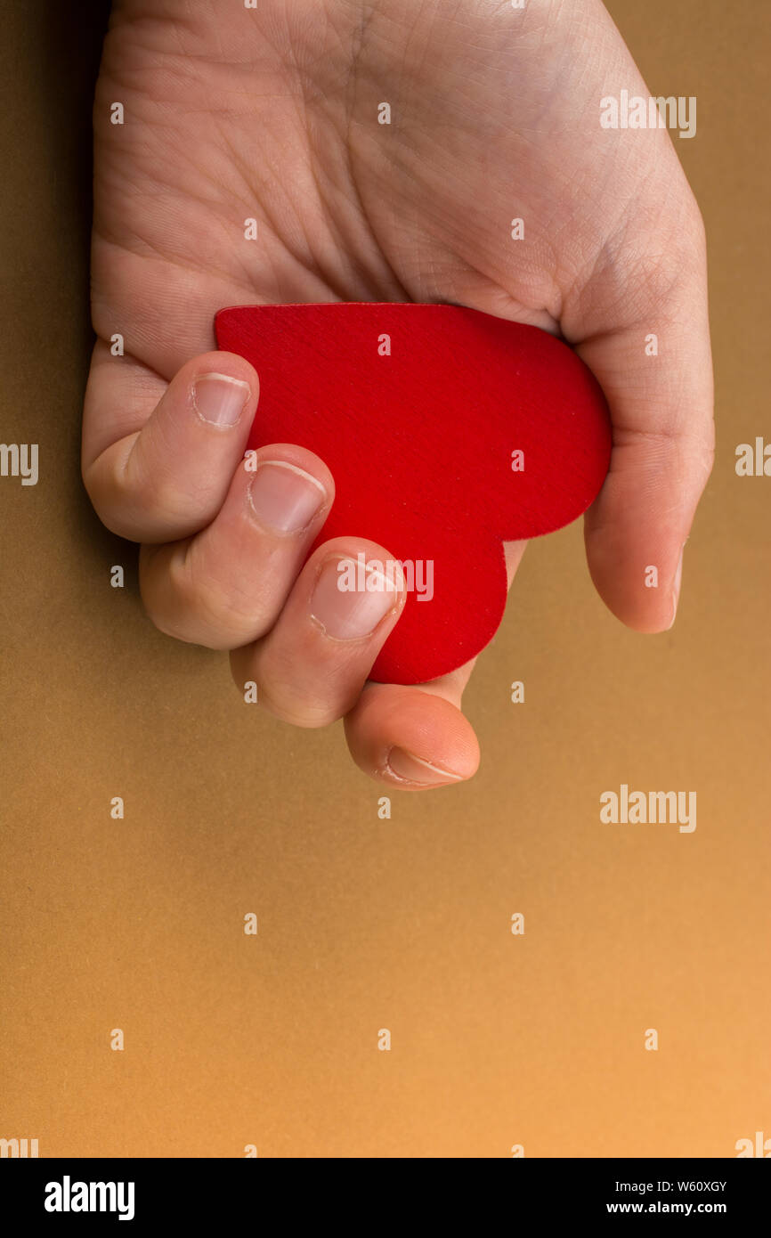 Red color heart shaped object in hand on dotted paper Stock Photo - Alamy