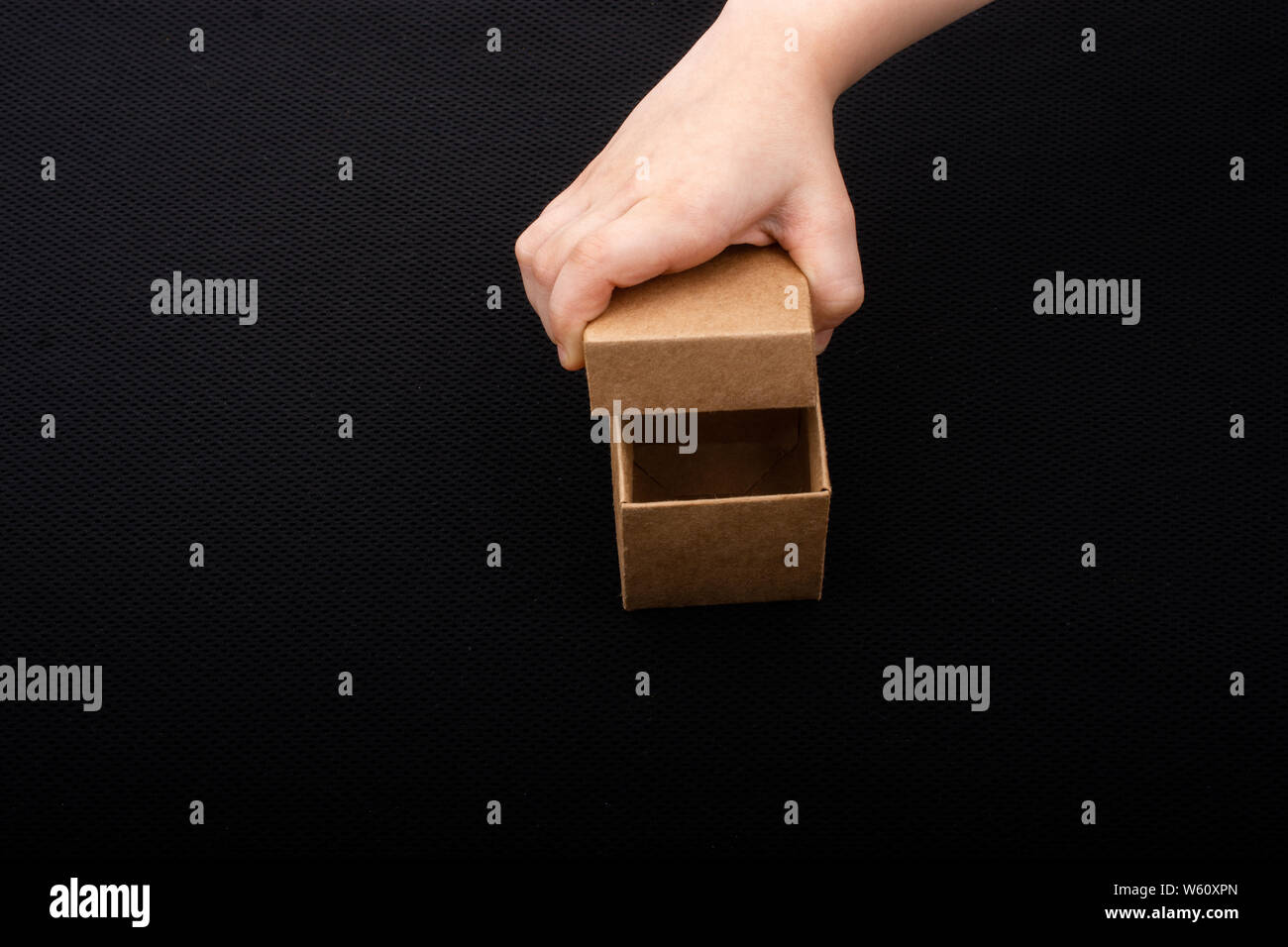 Hand opening a brown cardboard box on black backgrounds Stock Photo - Alamy