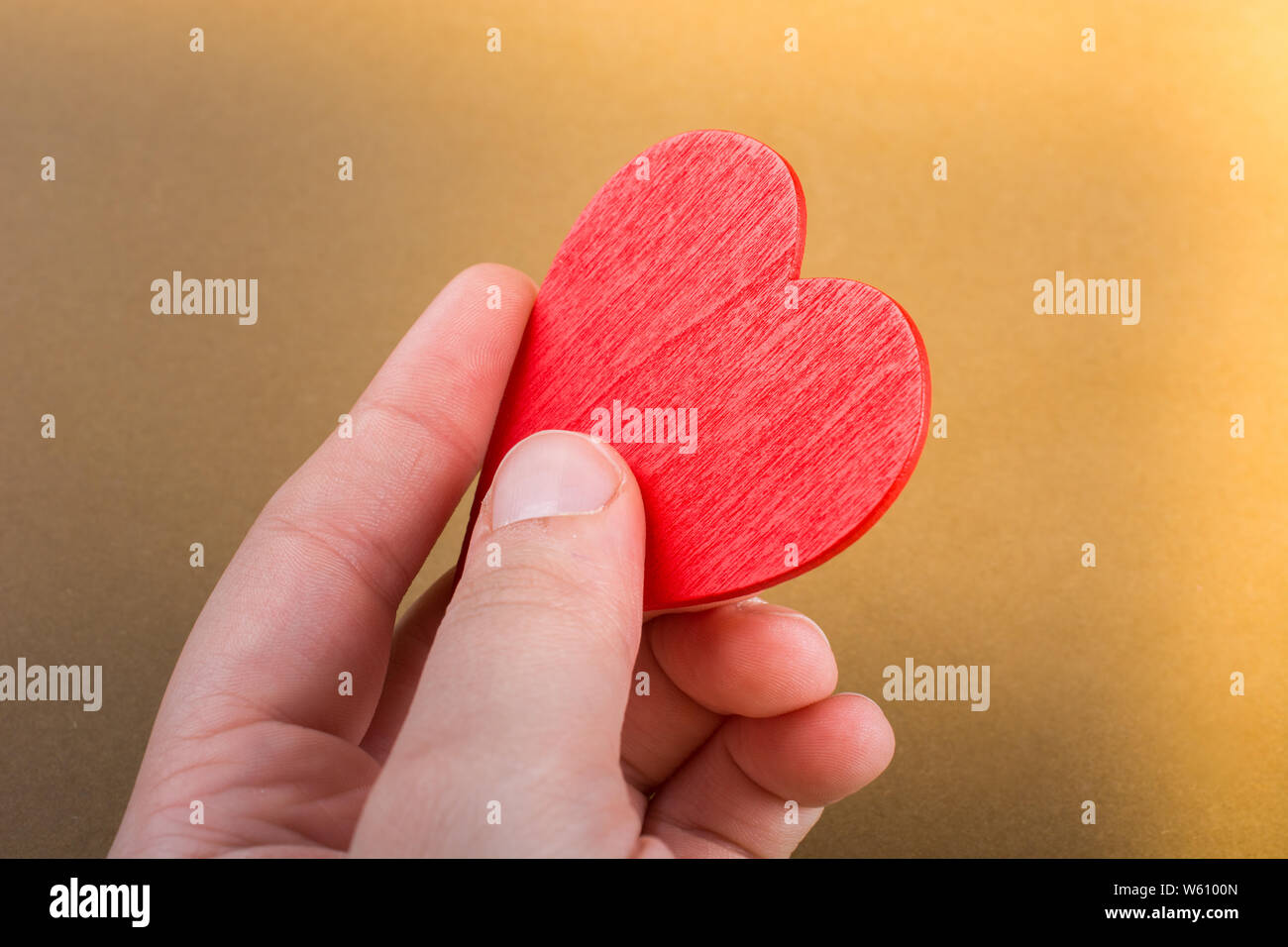 Red color heart shaped object in hand on dotted paper Stock Photo - Alamy