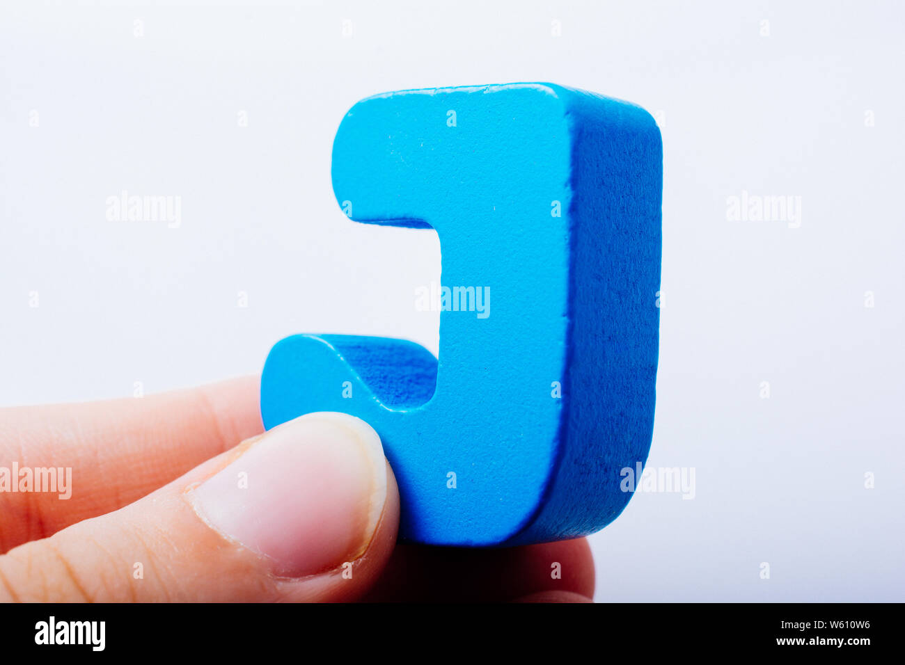 Hand holding Letter cube J of Alphabet Stock Photo - Alamy