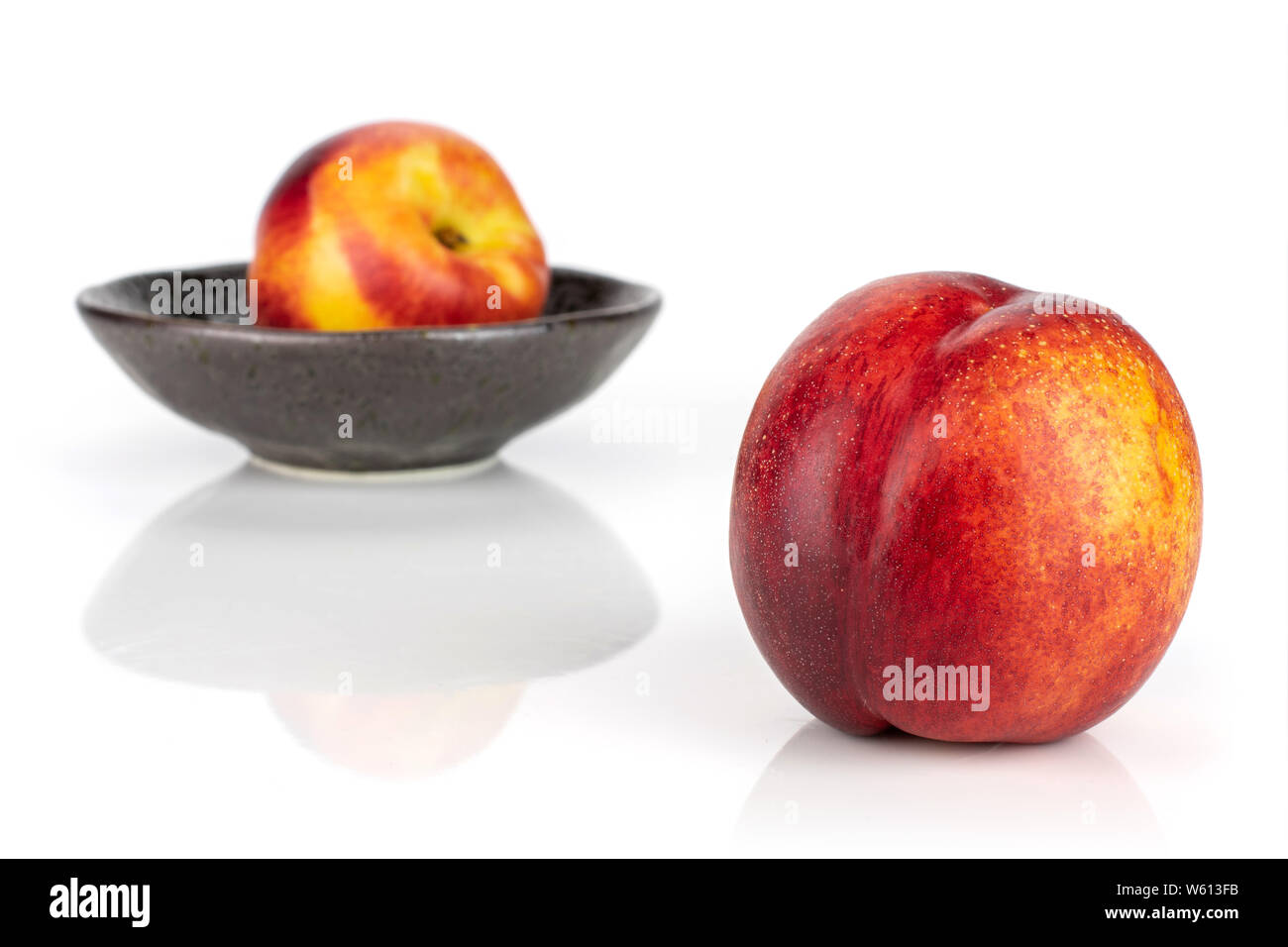 Group of two whole fresh red nectarine one is in the front and the ...