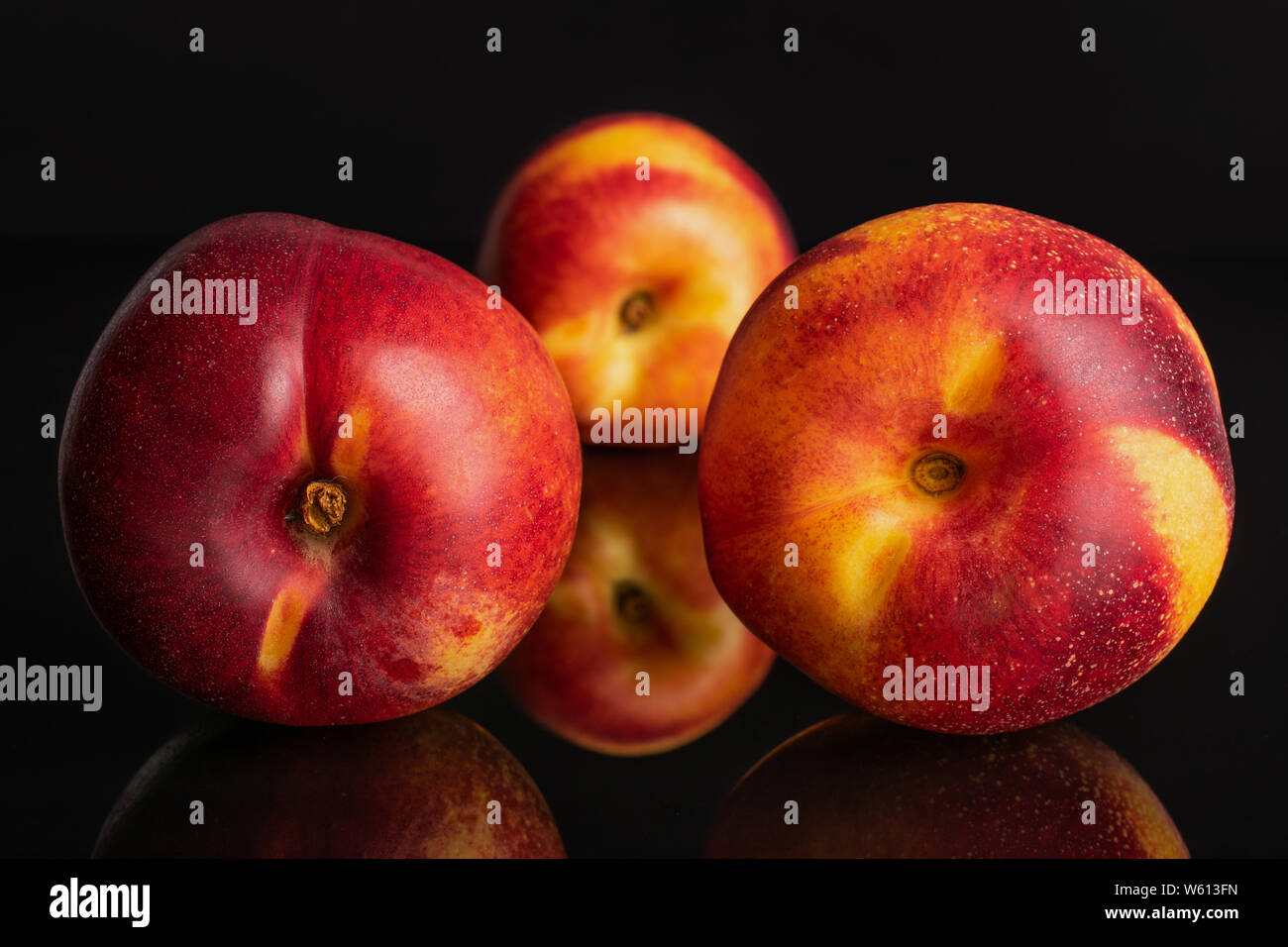 Group of three whole fresh red nectarine two in the front and one in ...