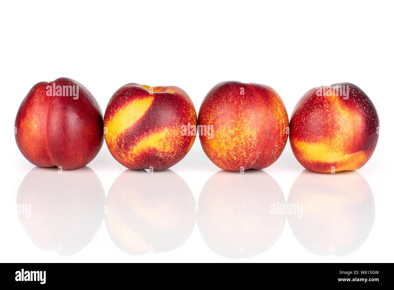 Group of four whole fresh red nectarine in a row isolated on white ...