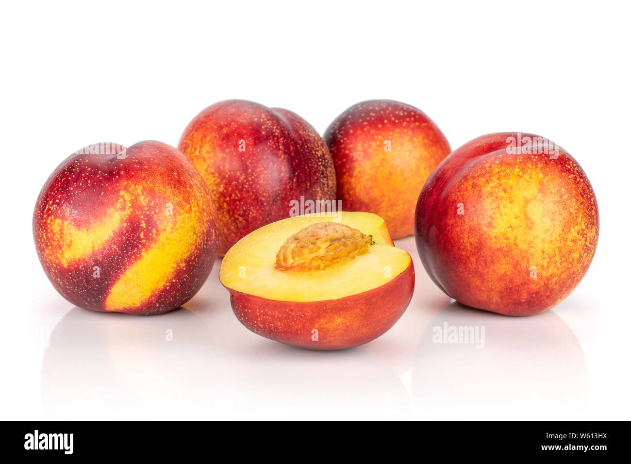Group of four whole one half of fresh red nectarine isolated on white ...