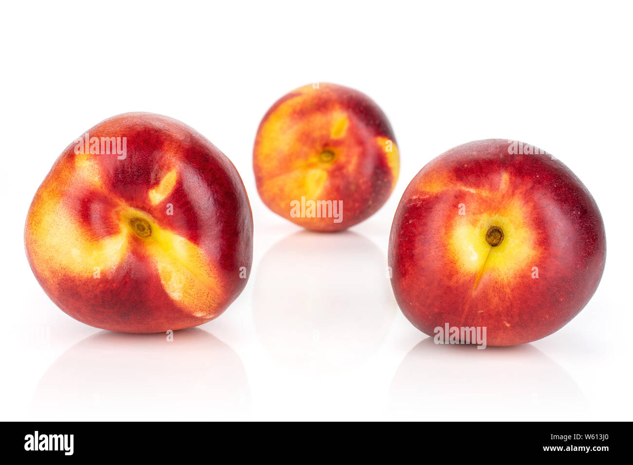 Group of three whole fresh red nectarine two are in the front isolated ...