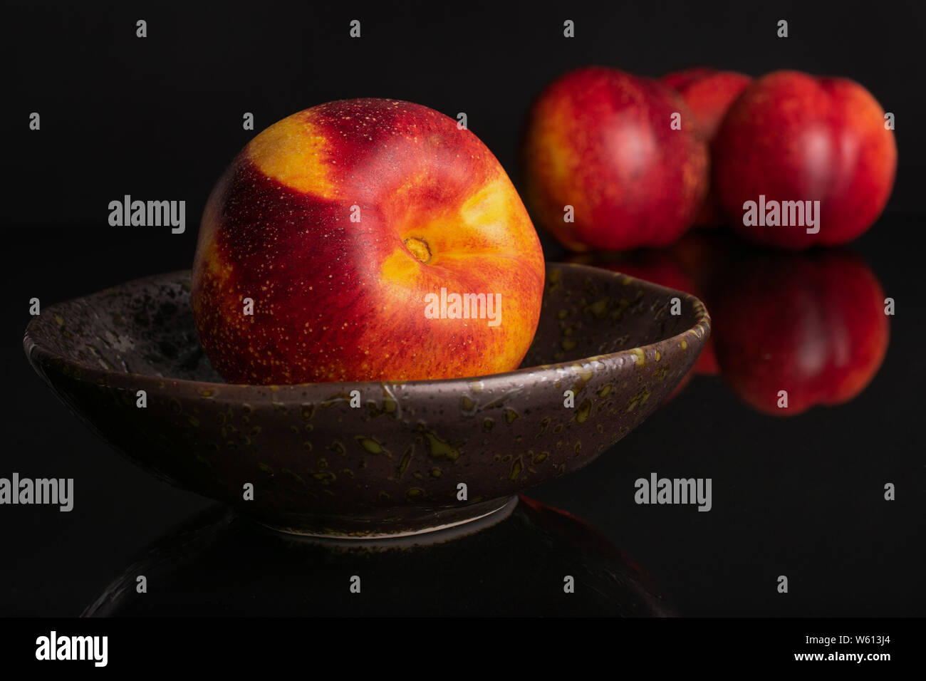 Group of four whole fresh red nectarine three are in the back and one ...