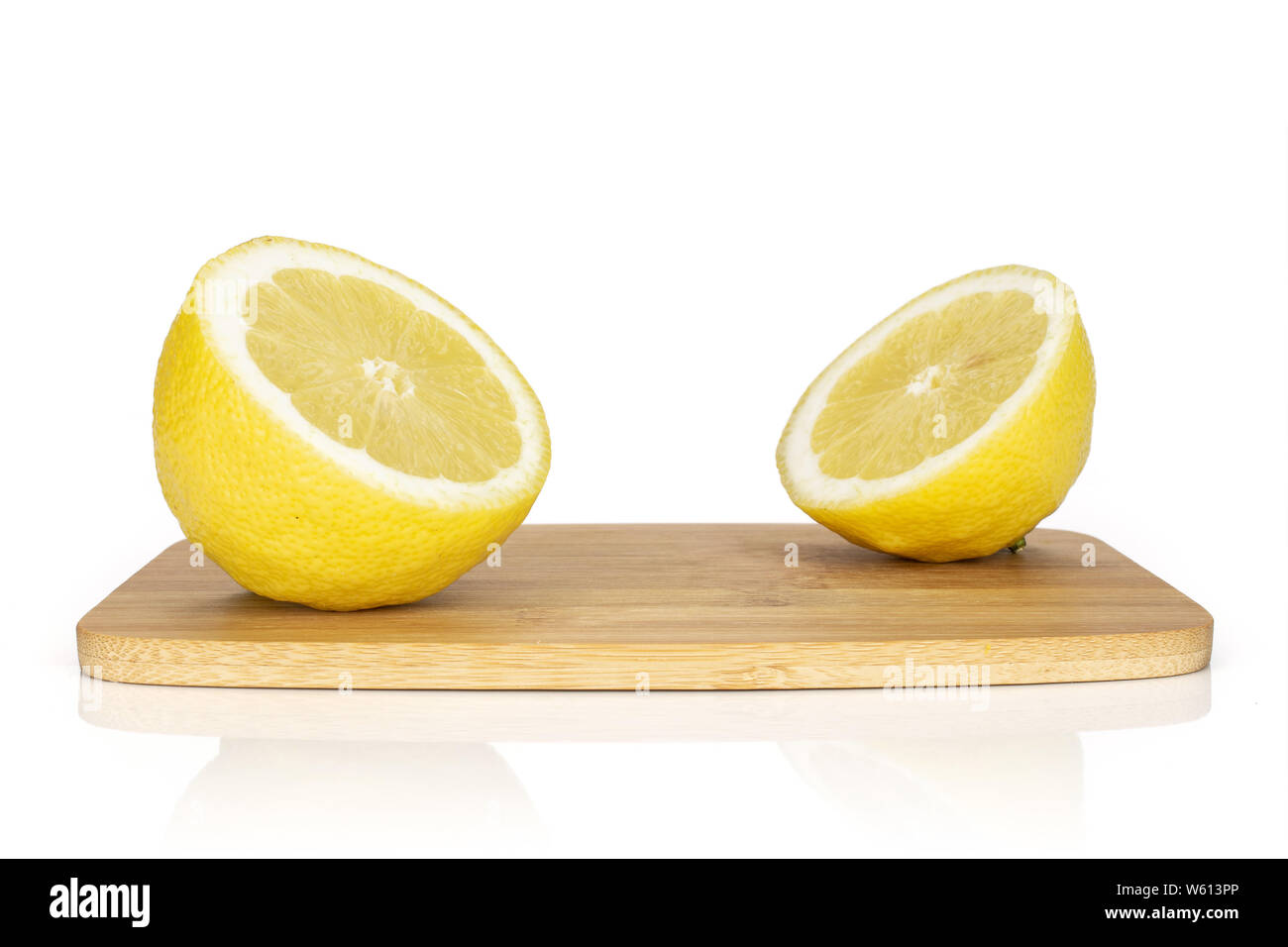 Group of two halves of fresh yellow lemon on a bamboo cutting board ...
