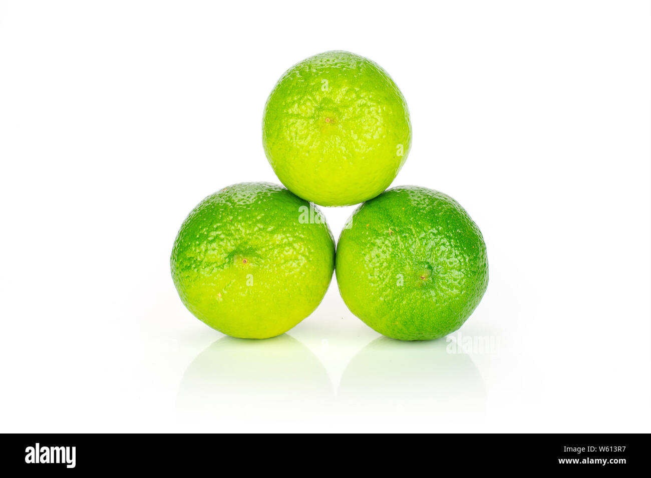 Group of three whole fresh green lime arranged in a pyramid isolated on ...