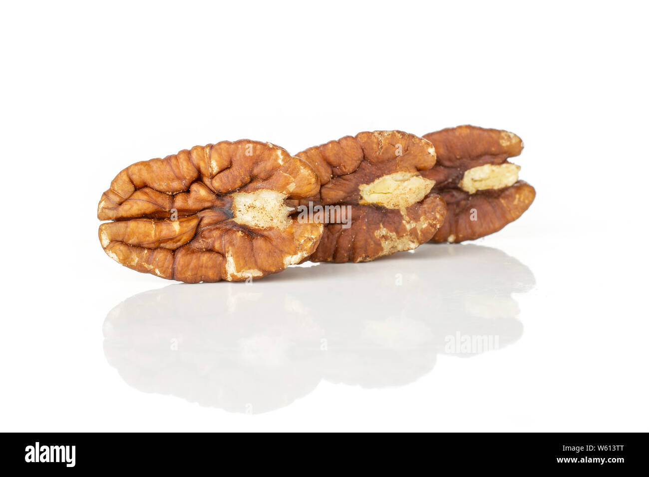 Group of three whole fresh brown pecan nut half in row isolated on ...