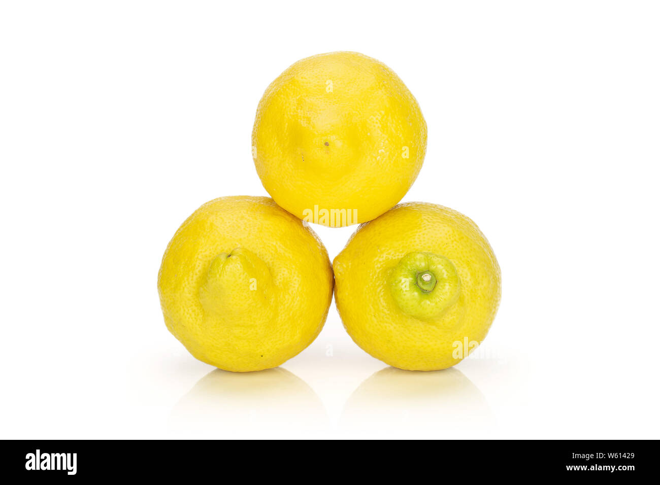 Group of three whole fresh yellow lemon arranged in a pyramid isolated ...