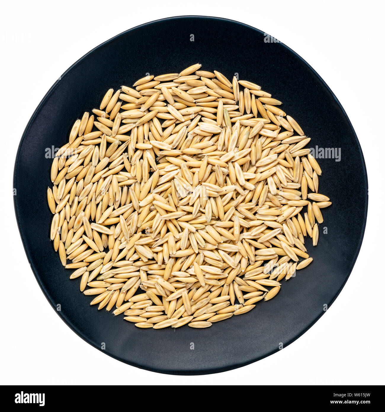 whole, organic oat groats - top view of an isolated black plate Stock ...
