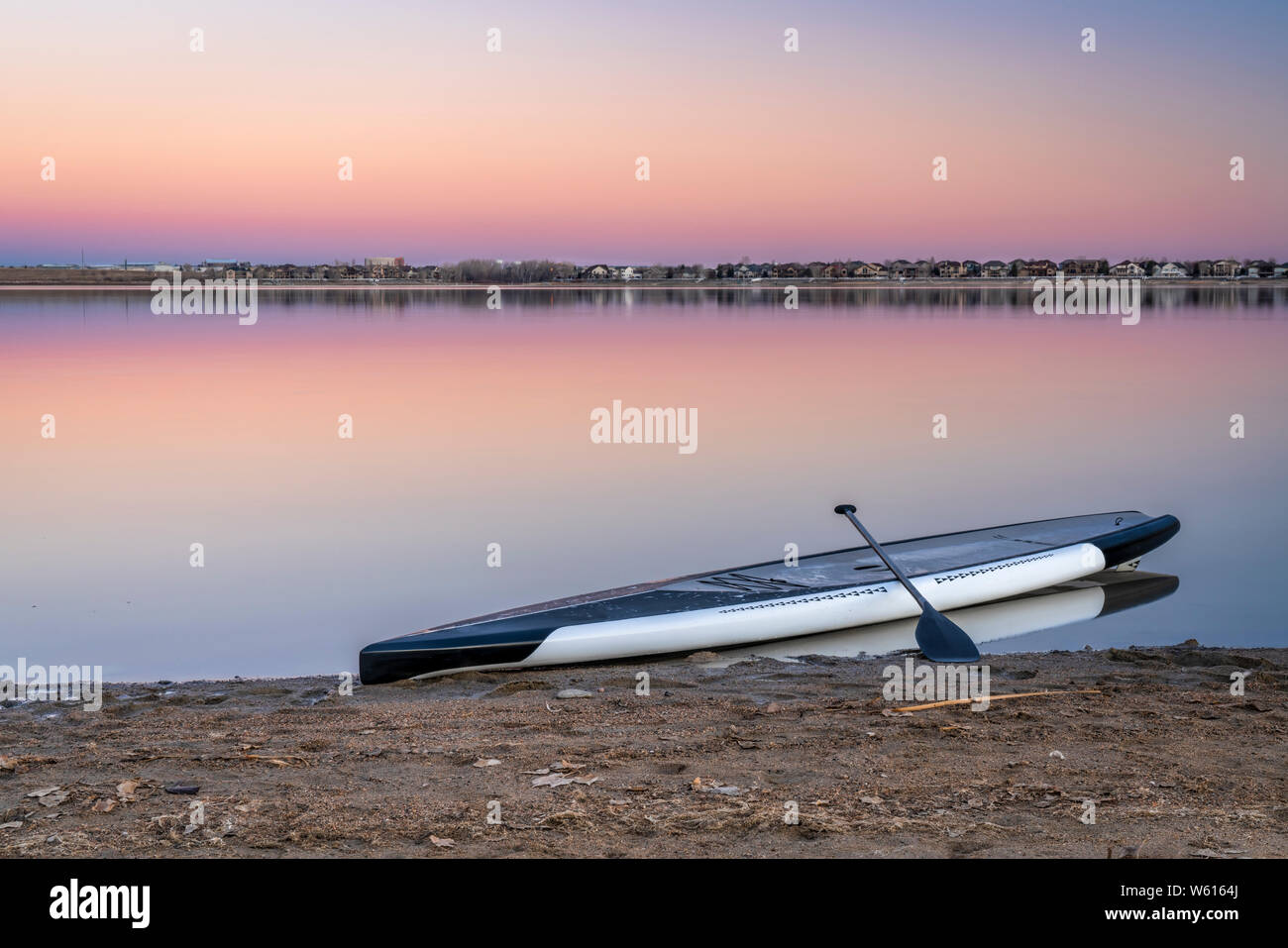dusk over lake in Colorado with a stand up paddleboard on a beach Stock ...