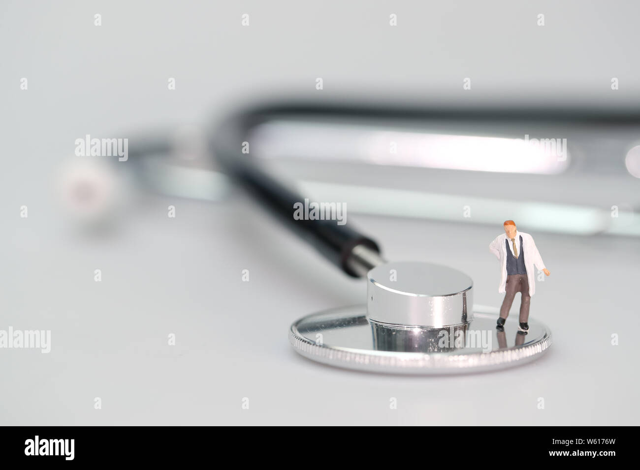 Miniature people: doctor standing with stethoscope using for medical ...